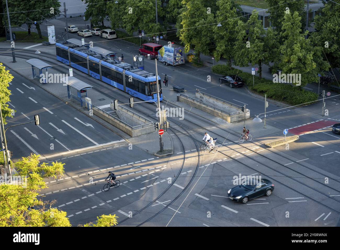View from above of a road crossing with tram and tram stop, cyclist and ...