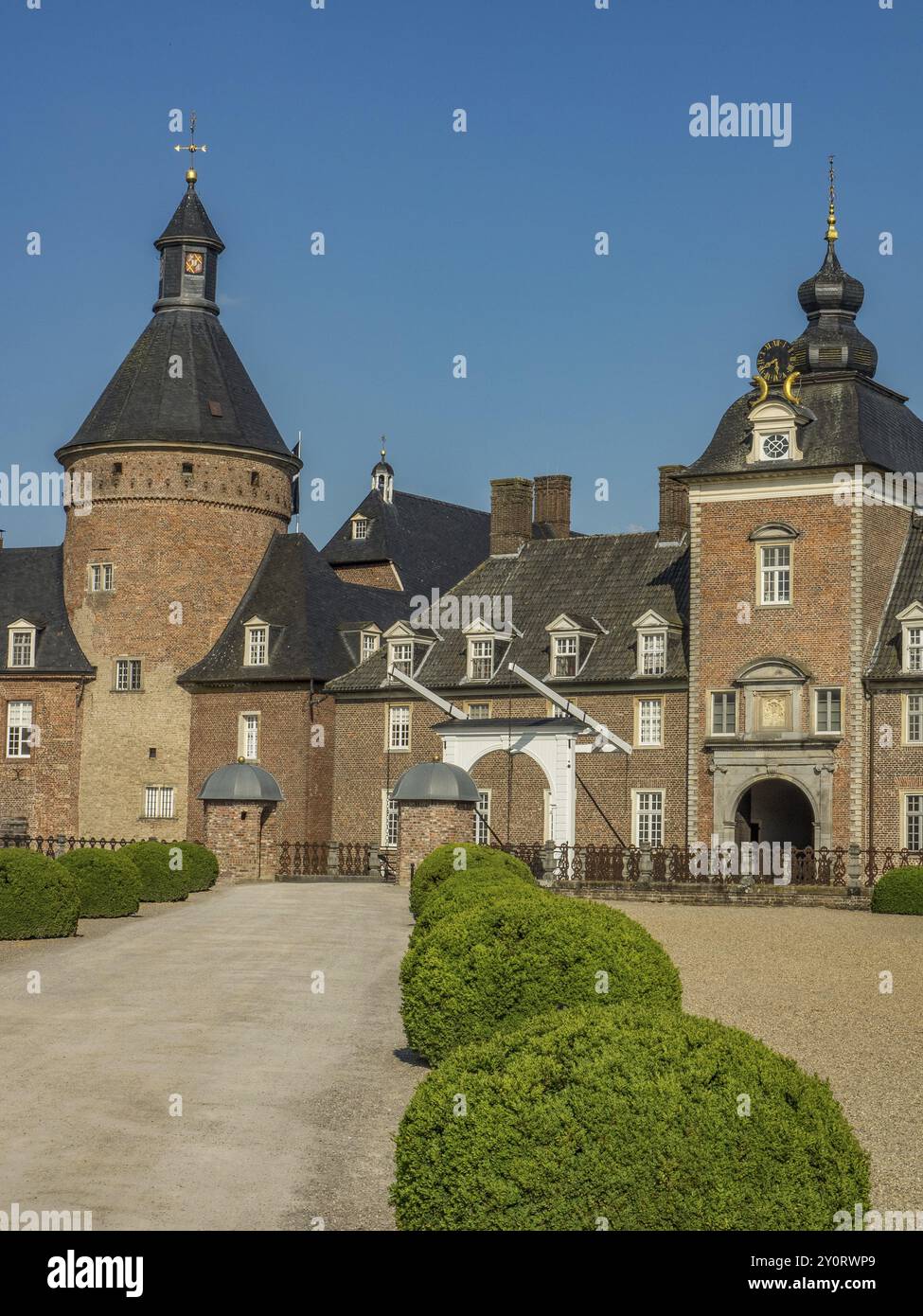 Historic castle with brick tower, classic entrance gate and manicured ...