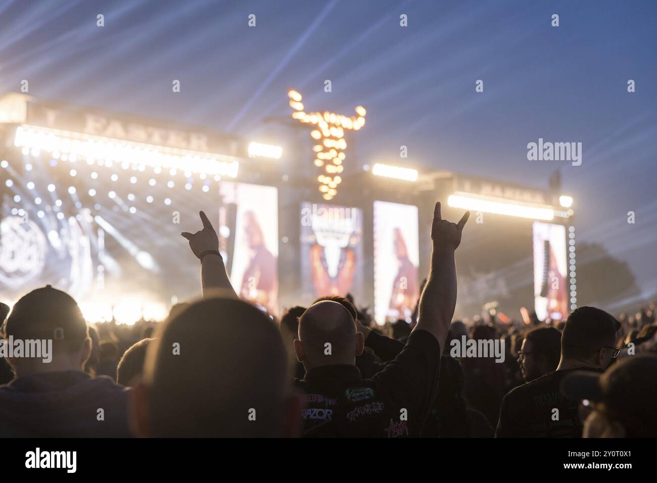 A festival visitor shows the devil's salute in front of the two main ...