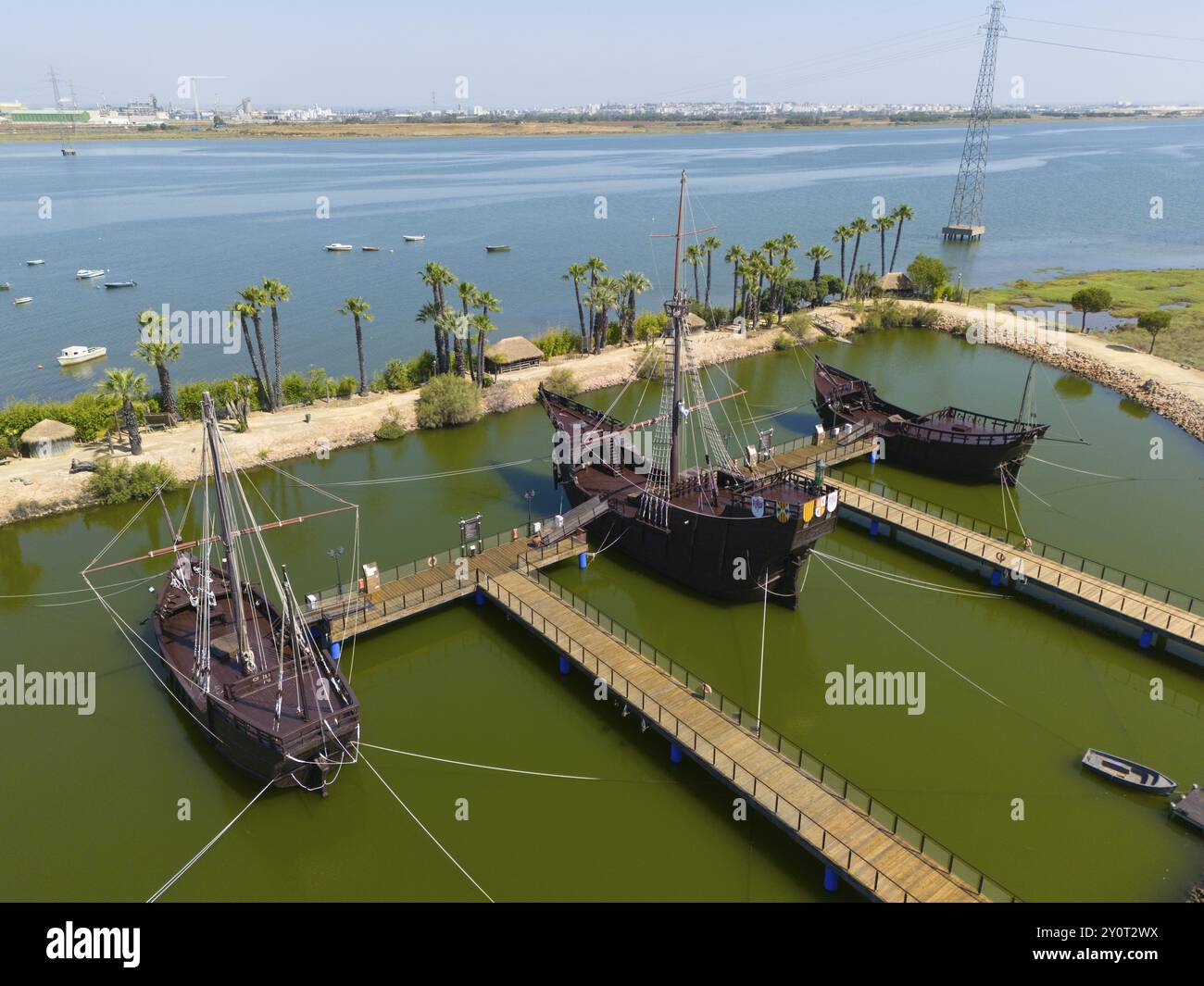 Wooden docks with replica medieval ships on the shore of a calm lake ...