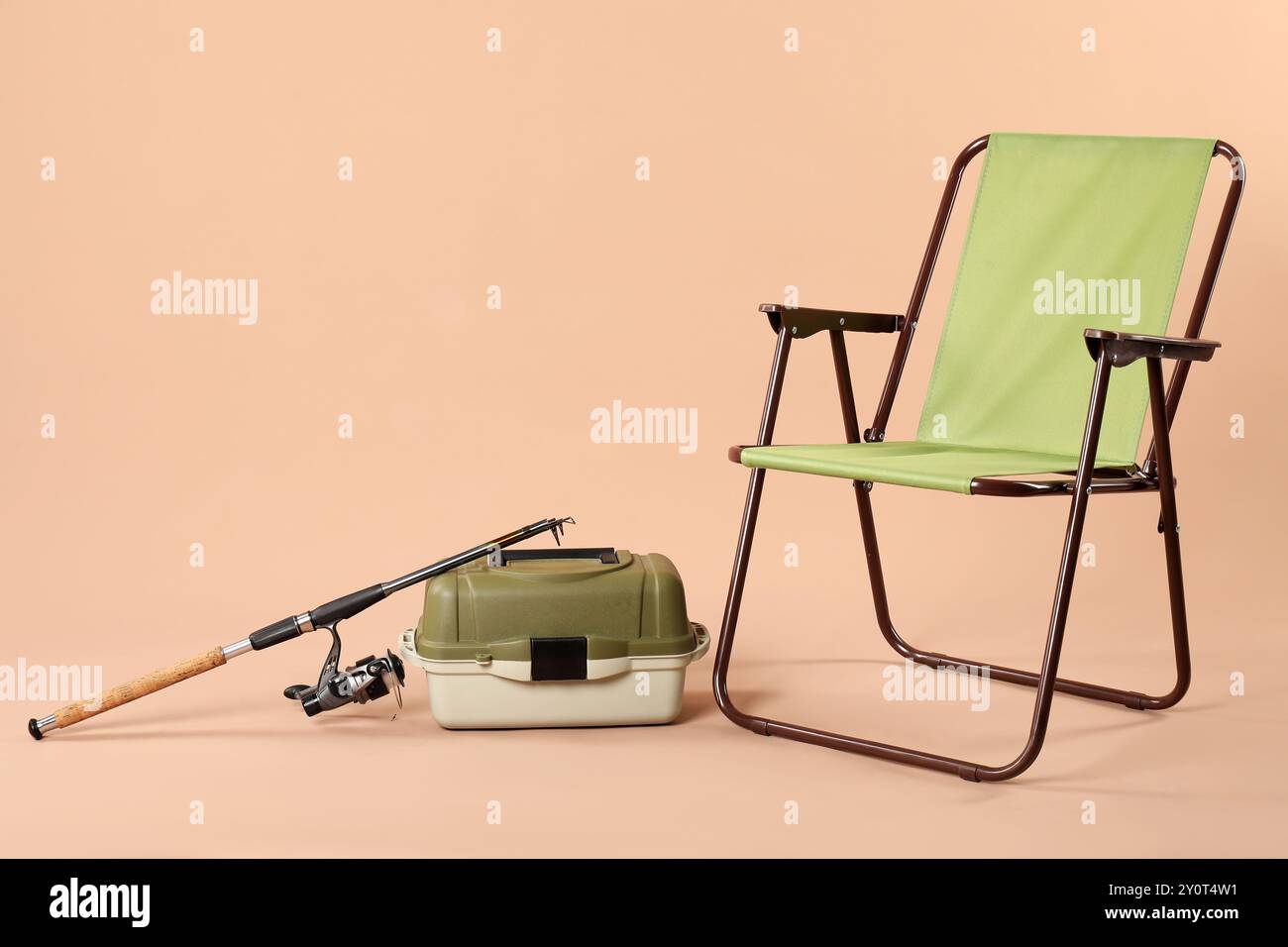 Folding chair, fishing rod and tackle box on beige background Stock ...