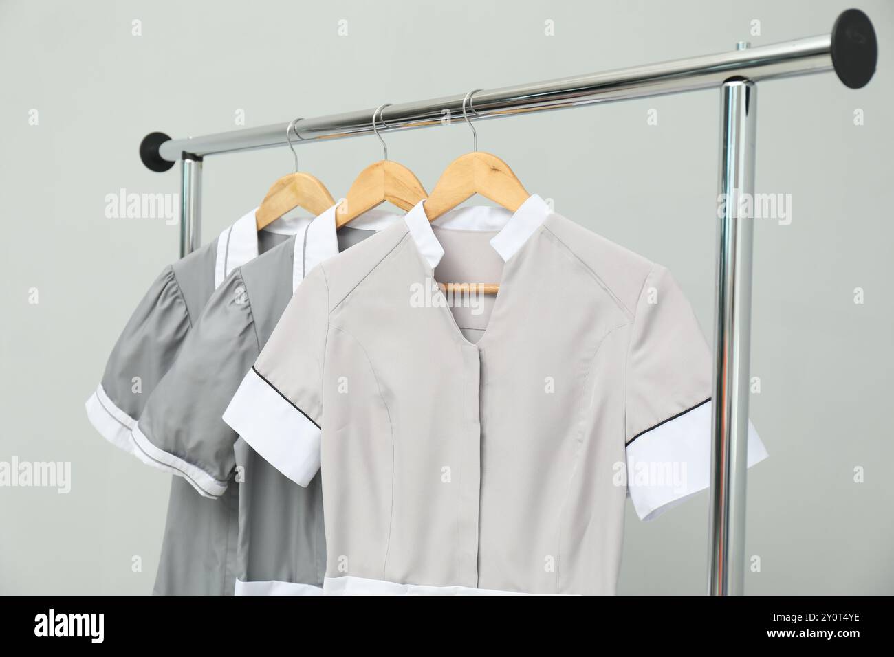 Maids' uniforms on clothing rack against grey background Stock Photo ...
