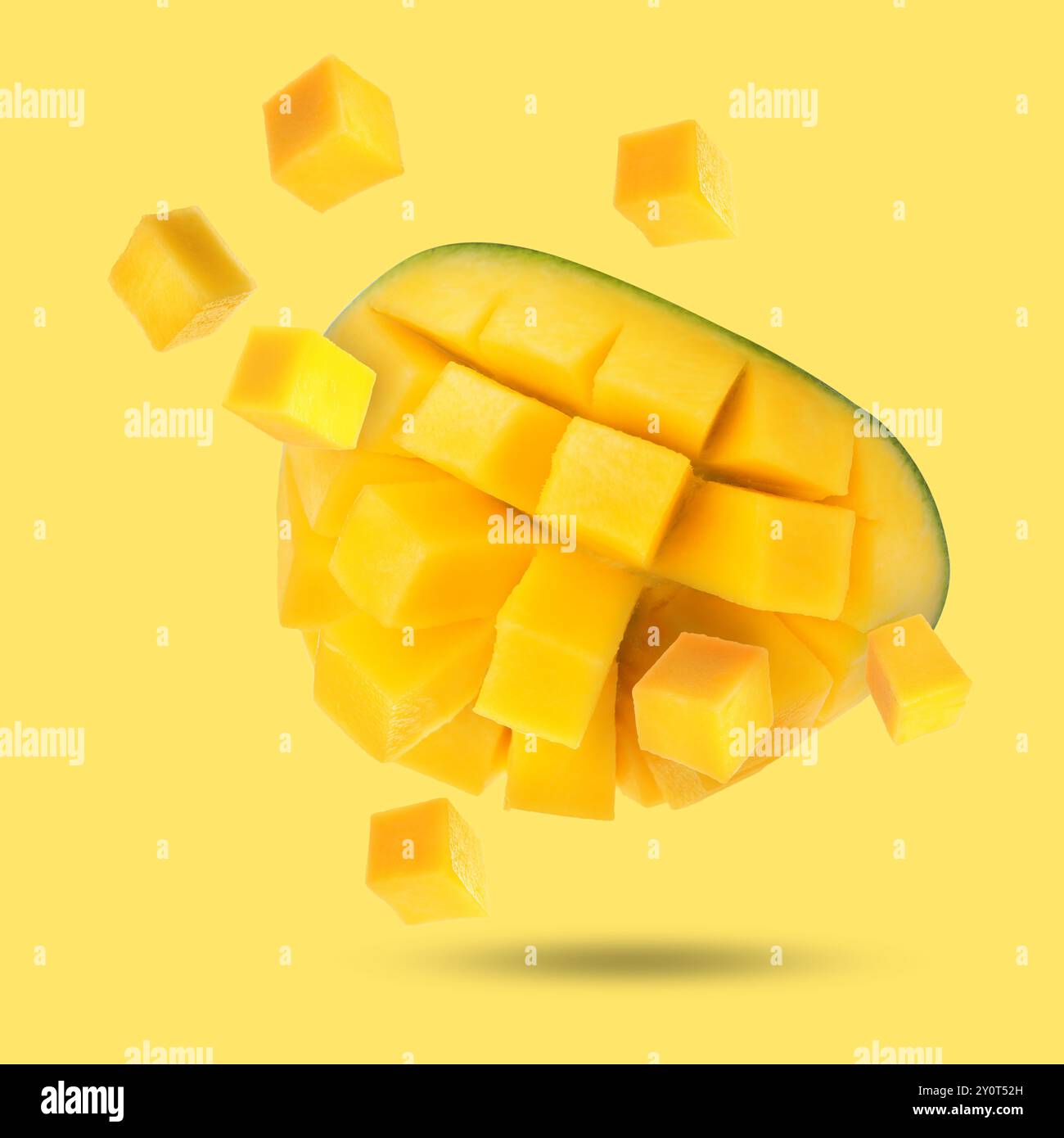Sweet fresh mango cut in cubes falling on yellow background Stock Photo ...