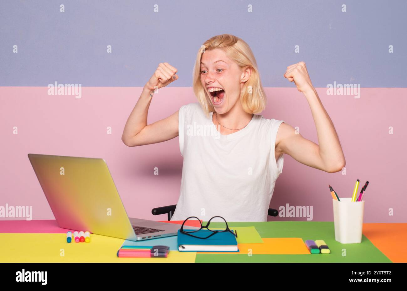 Excited amazed teacher works on laptop. Shcool teacher in class ...