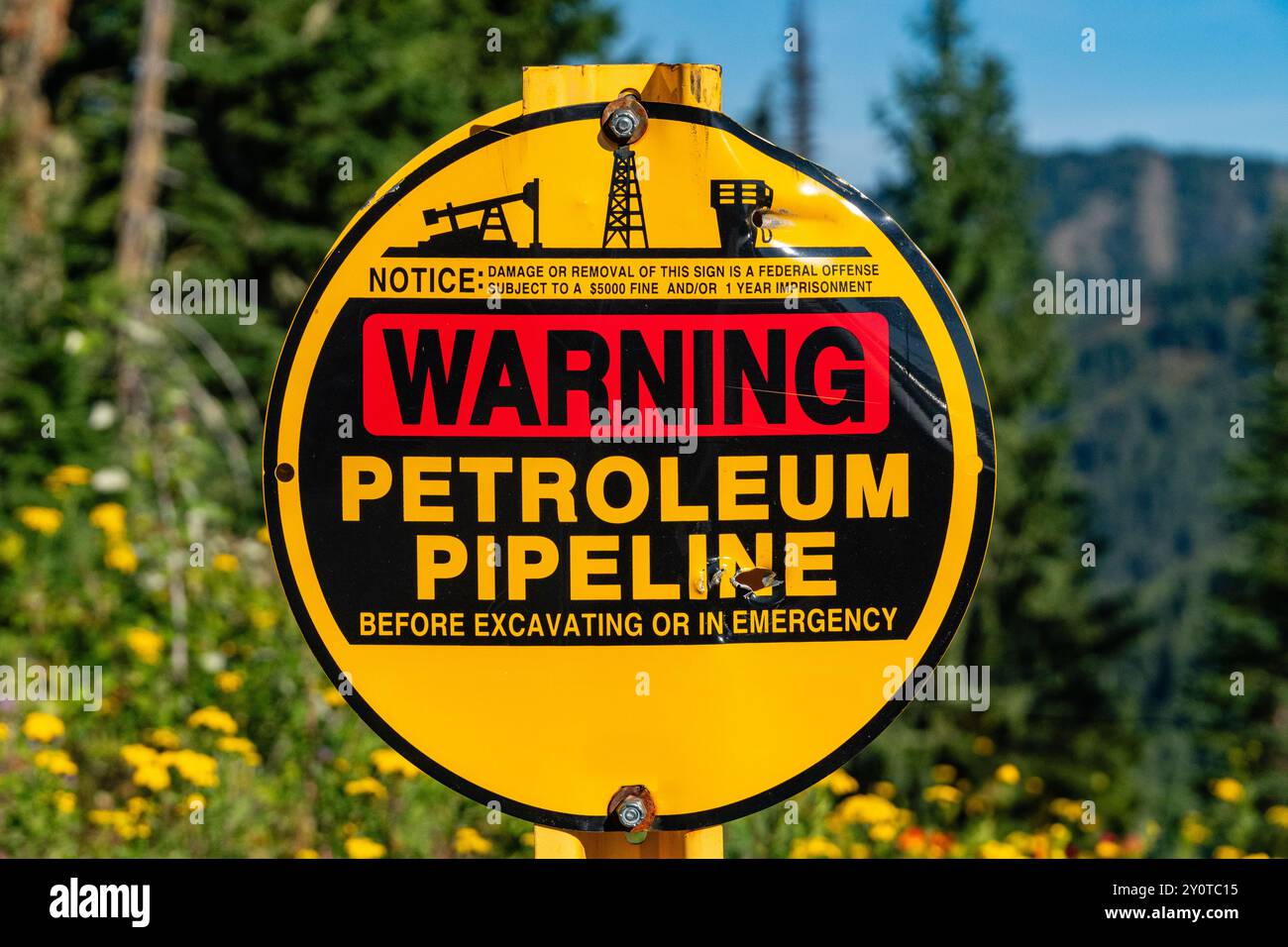 Close-up of bright yellow sign warning that a petroleum pipeline is ...