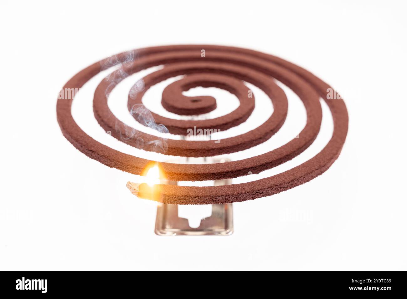 A mosquito coil with smoke coming out of it. The object is circular and ...
