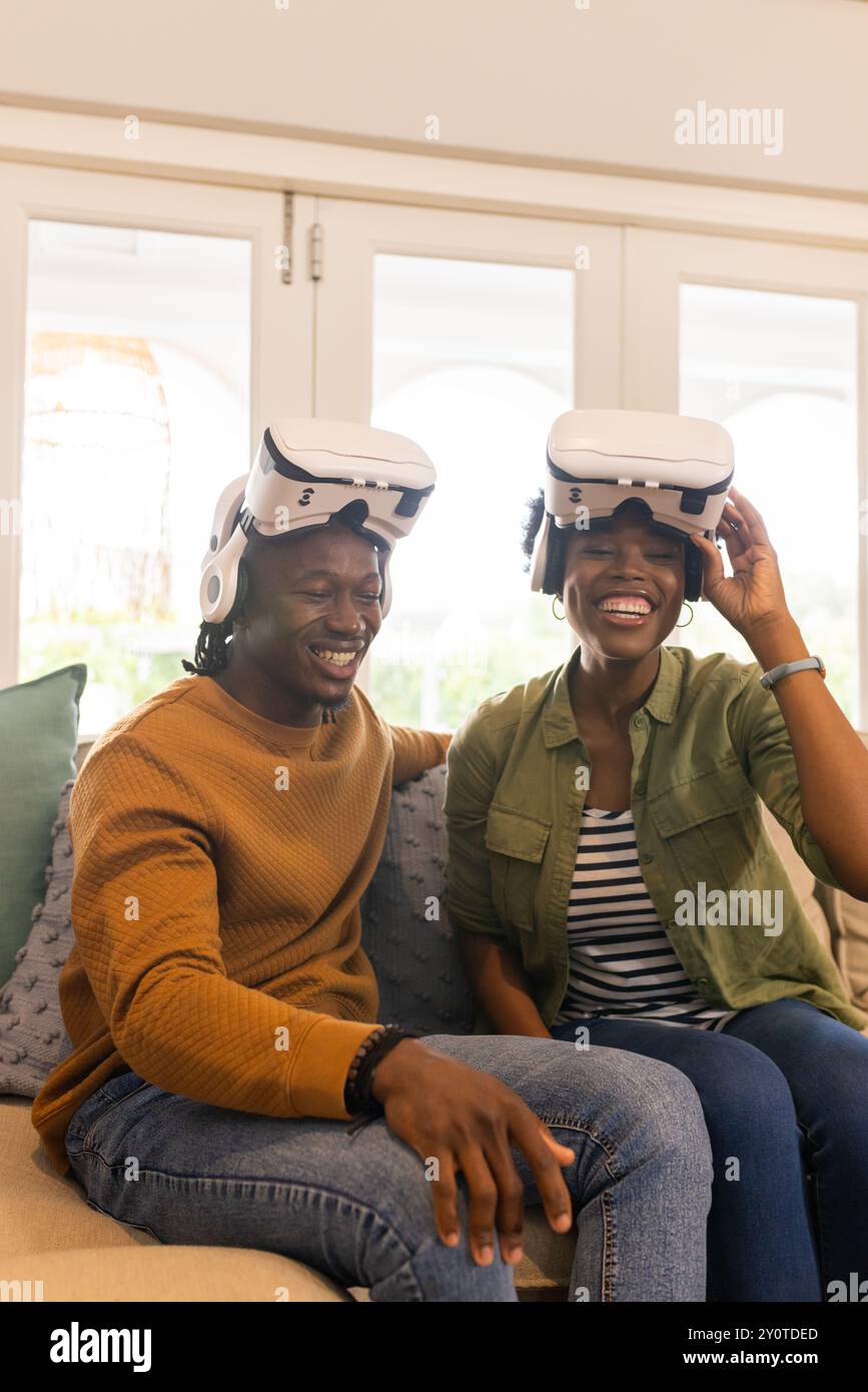 Using VR headsets, happy African American couple enjoying virtual ...