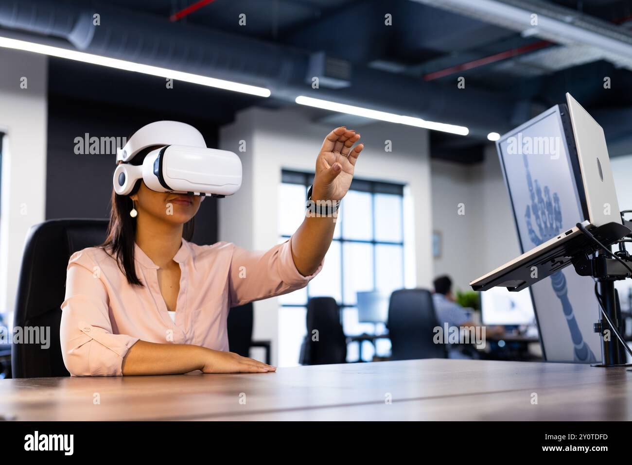 Using VR headset, woman interacting with virtual environment in modern office Stock Photo - Alamy