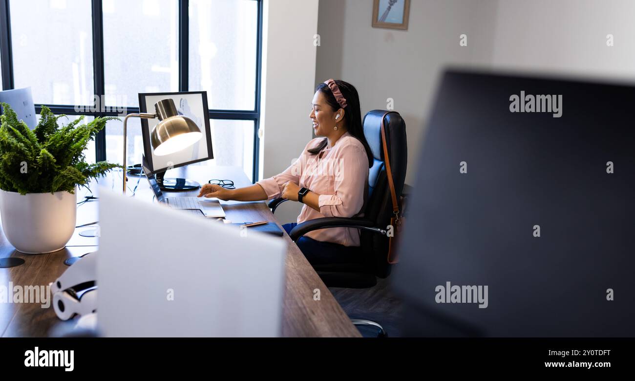 Working in modern office, woman using computer with robotic arm on desk ...
