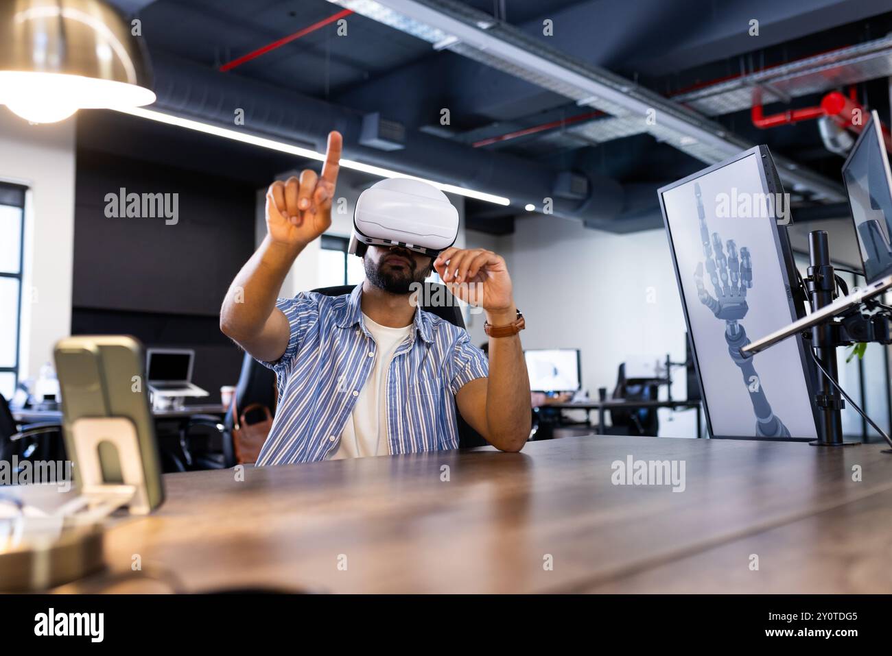 Using VR headset, Indian man interacting with virtual interface in ...