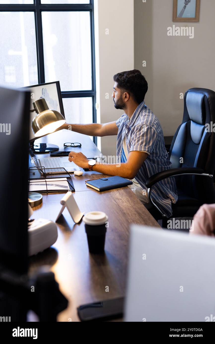 Working in modern office, Indian man using desktop computer and ...