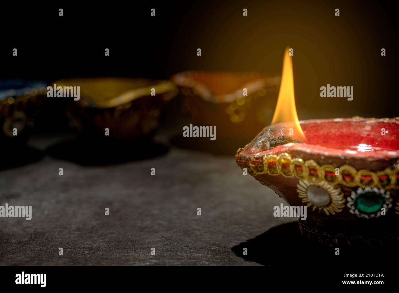 A row of small red and blue candles are lit, creating a warm and ...