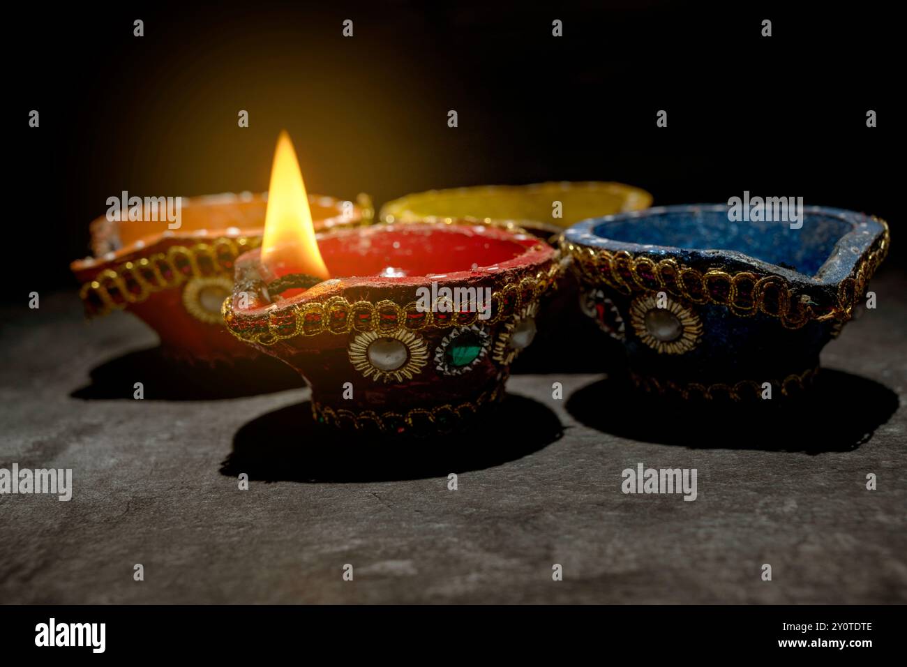 A row of small red and blue candles are lit, creating a warm and ...