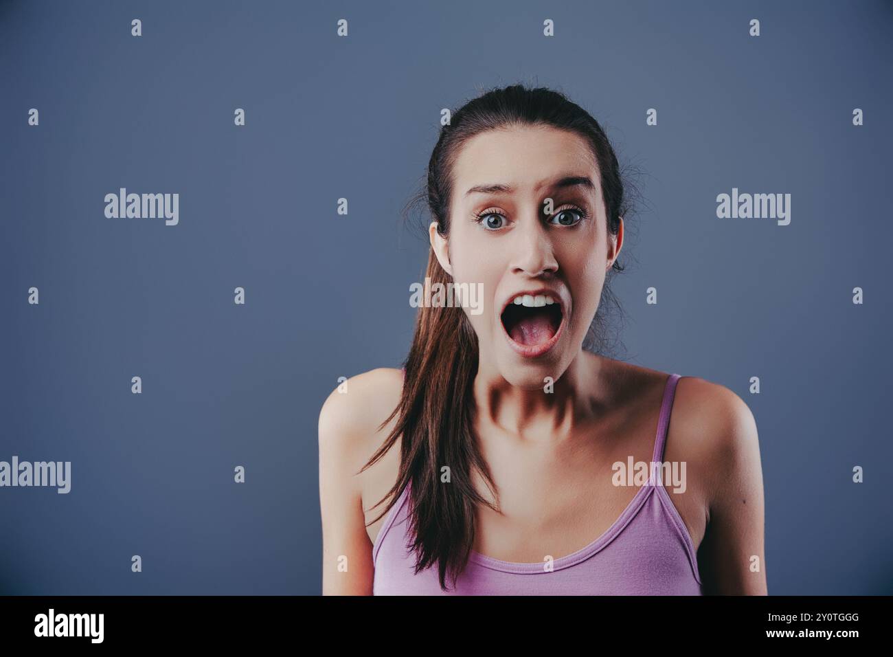 Young woman is experiencing a moment of intense shock or surprise, her ...