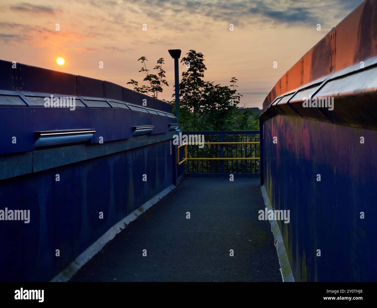 Sunrise over the railway footbridge at Radley Station. Radley is ...