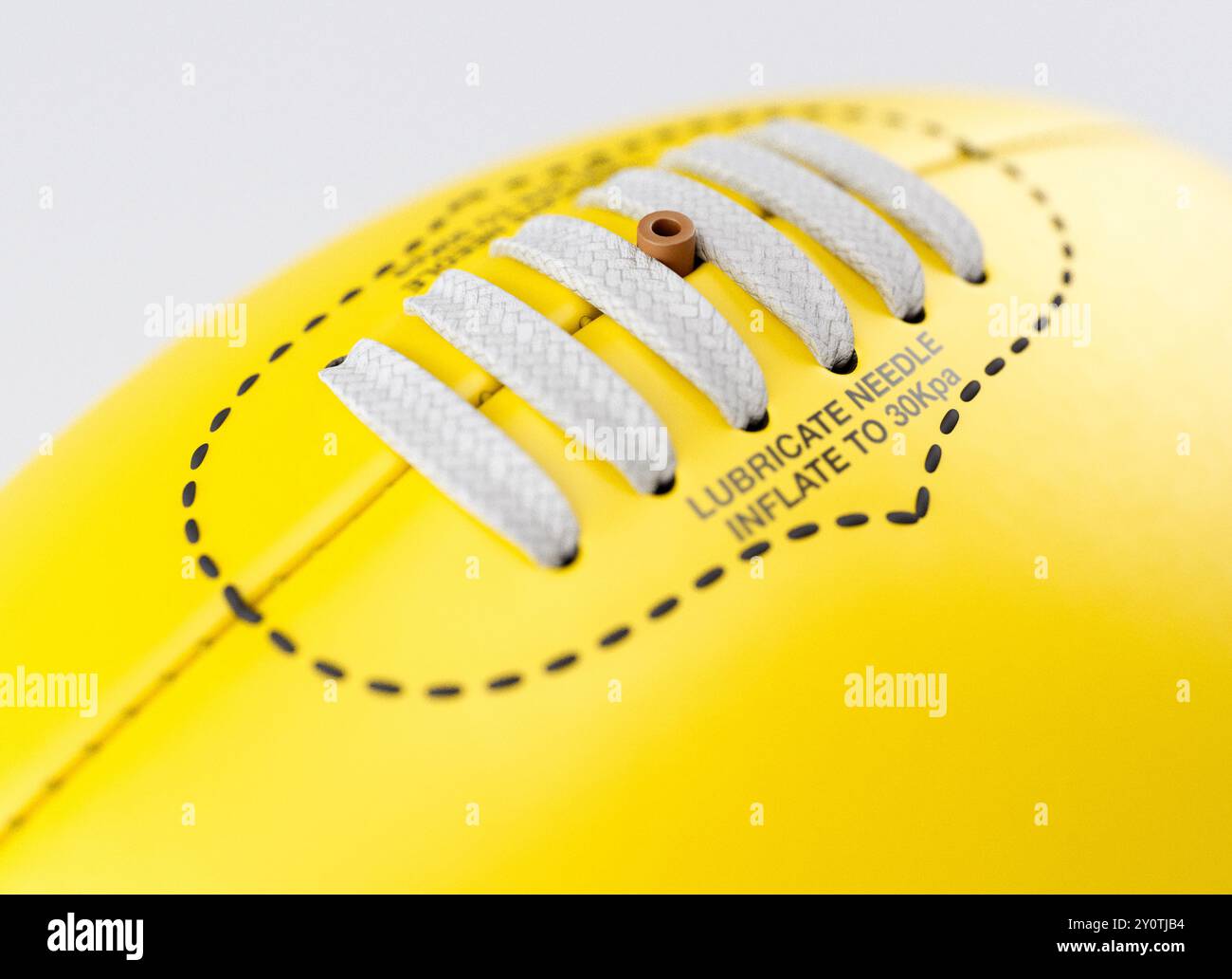 A generic unbranded yellow aussie rules football ball on an isolated ...