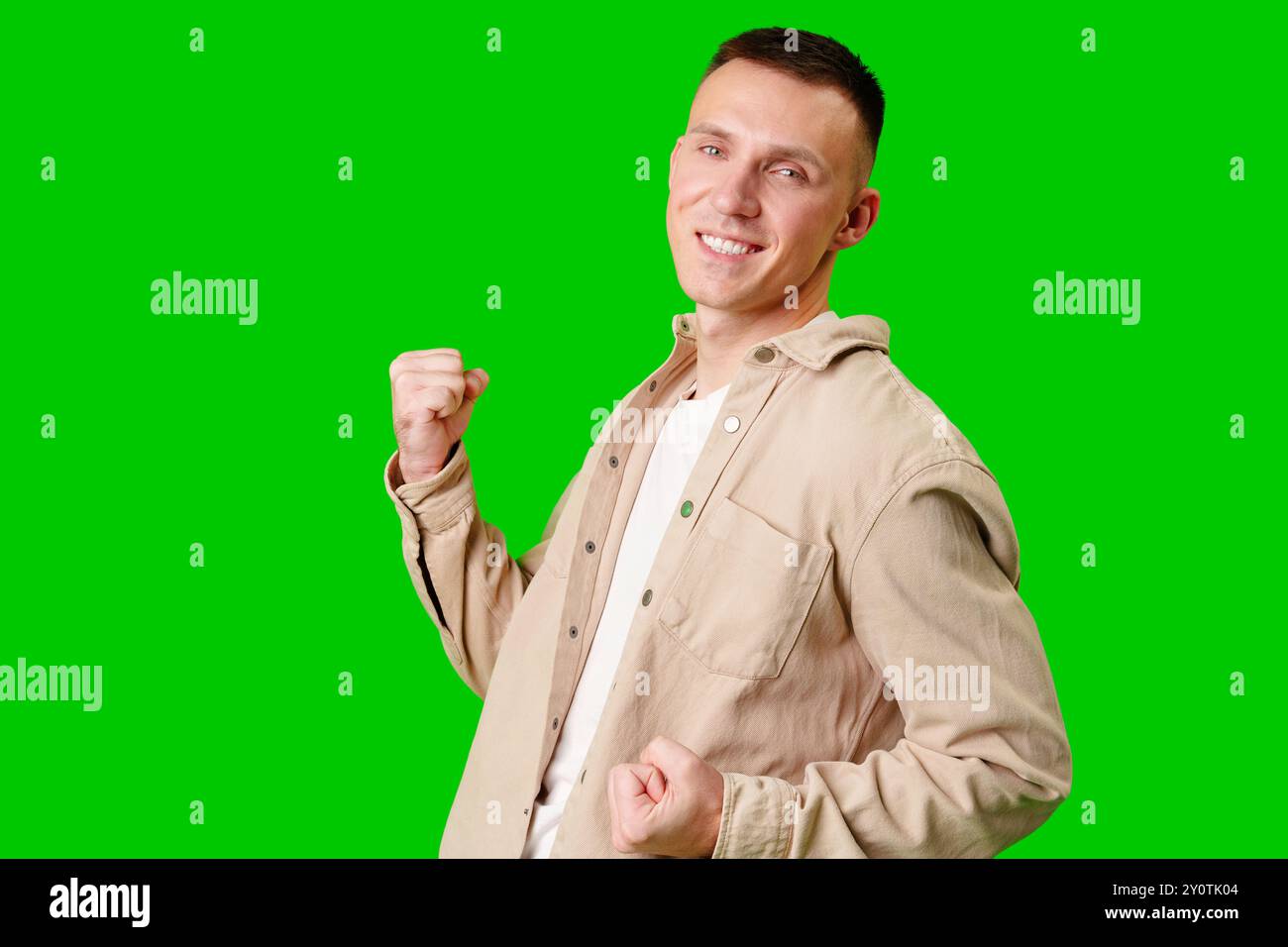 Young Man Celebrates Success With Energetic Pose Against Vibrant Green ...