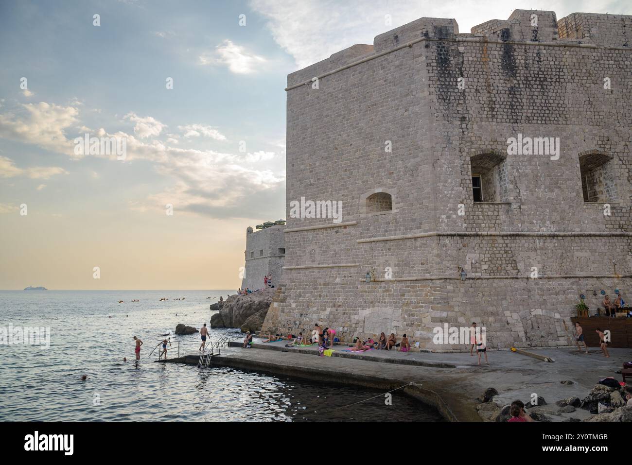 People swimming in the Adriatic Sea under the medieval walls of the Old ...