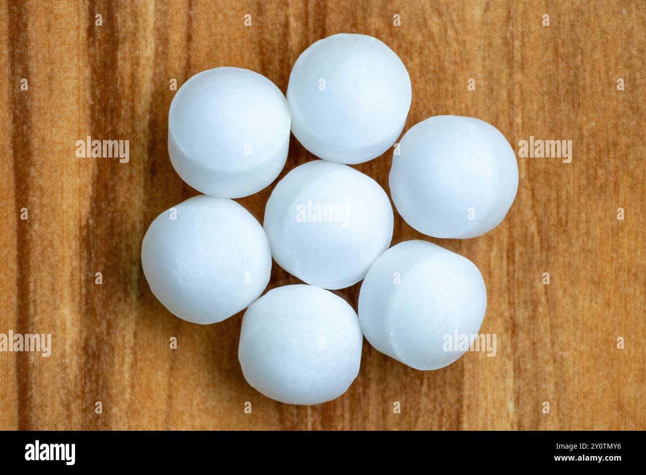 White Naphthalene balls isolated on wooden background. It is also known ...