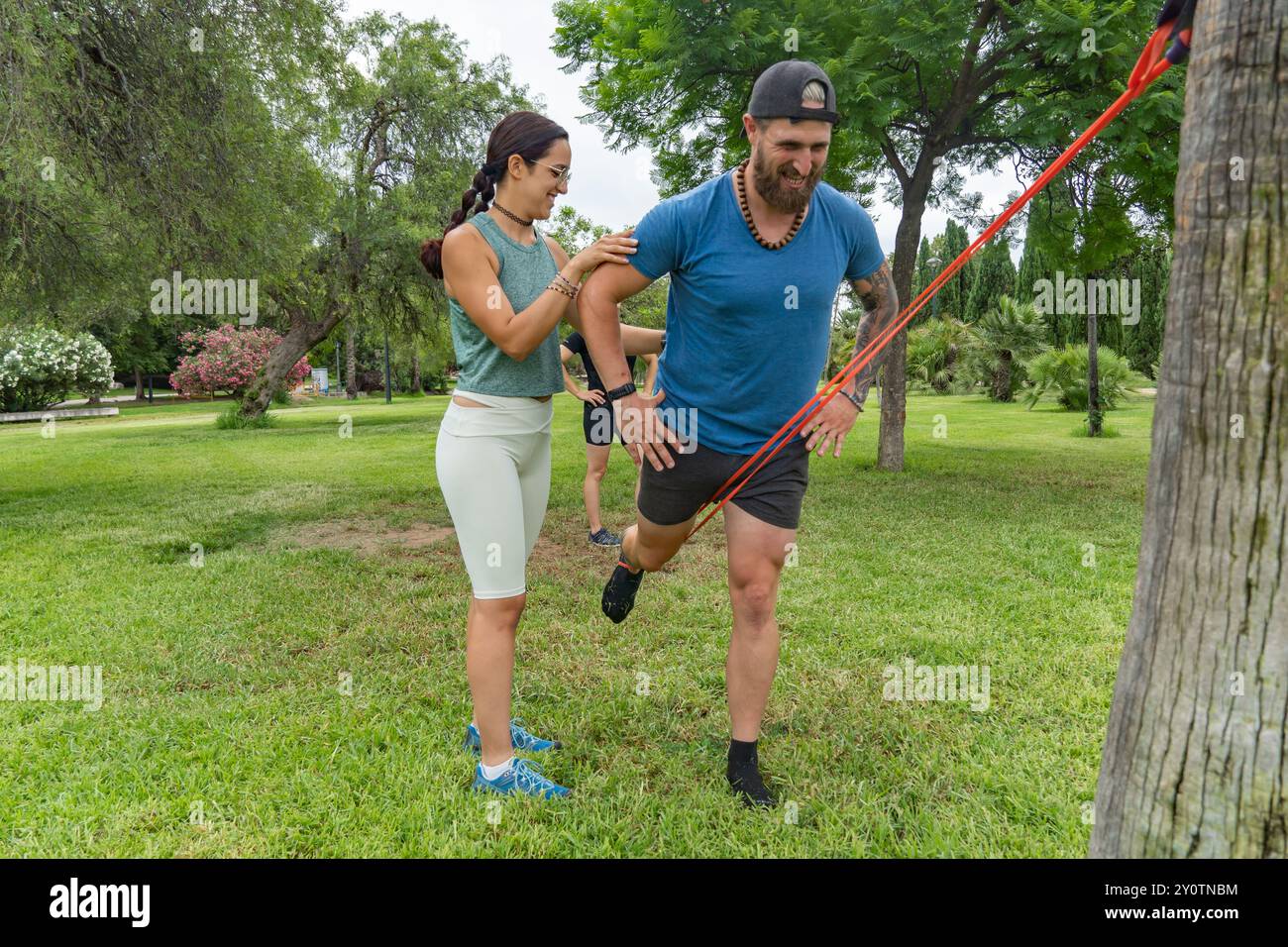 performing exercises with resistance bands for legs outdoors while ...