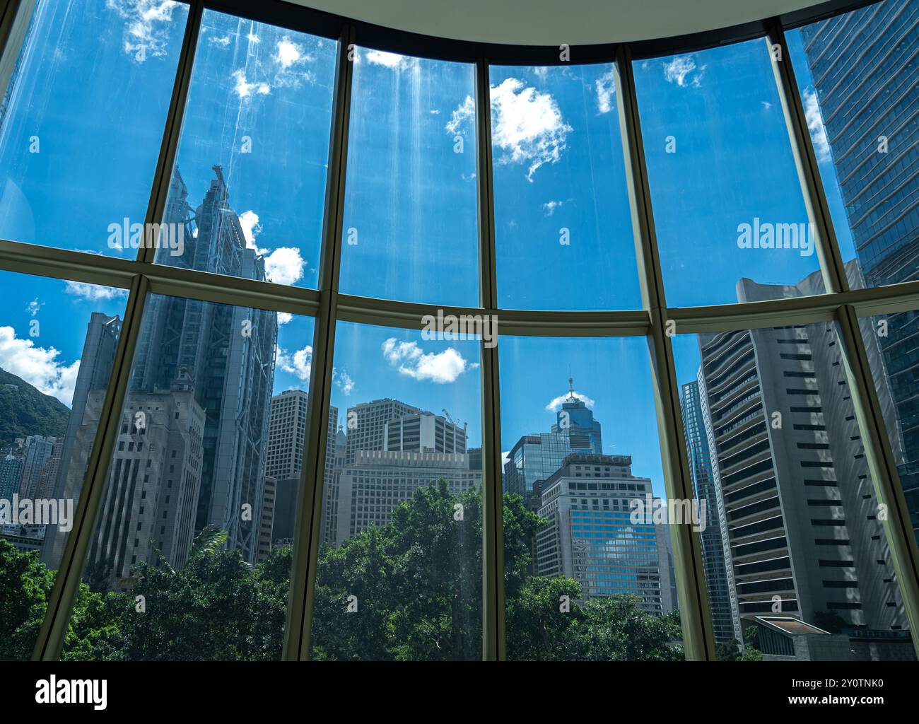 A view of a blue sky with white clouds through a large window with ...