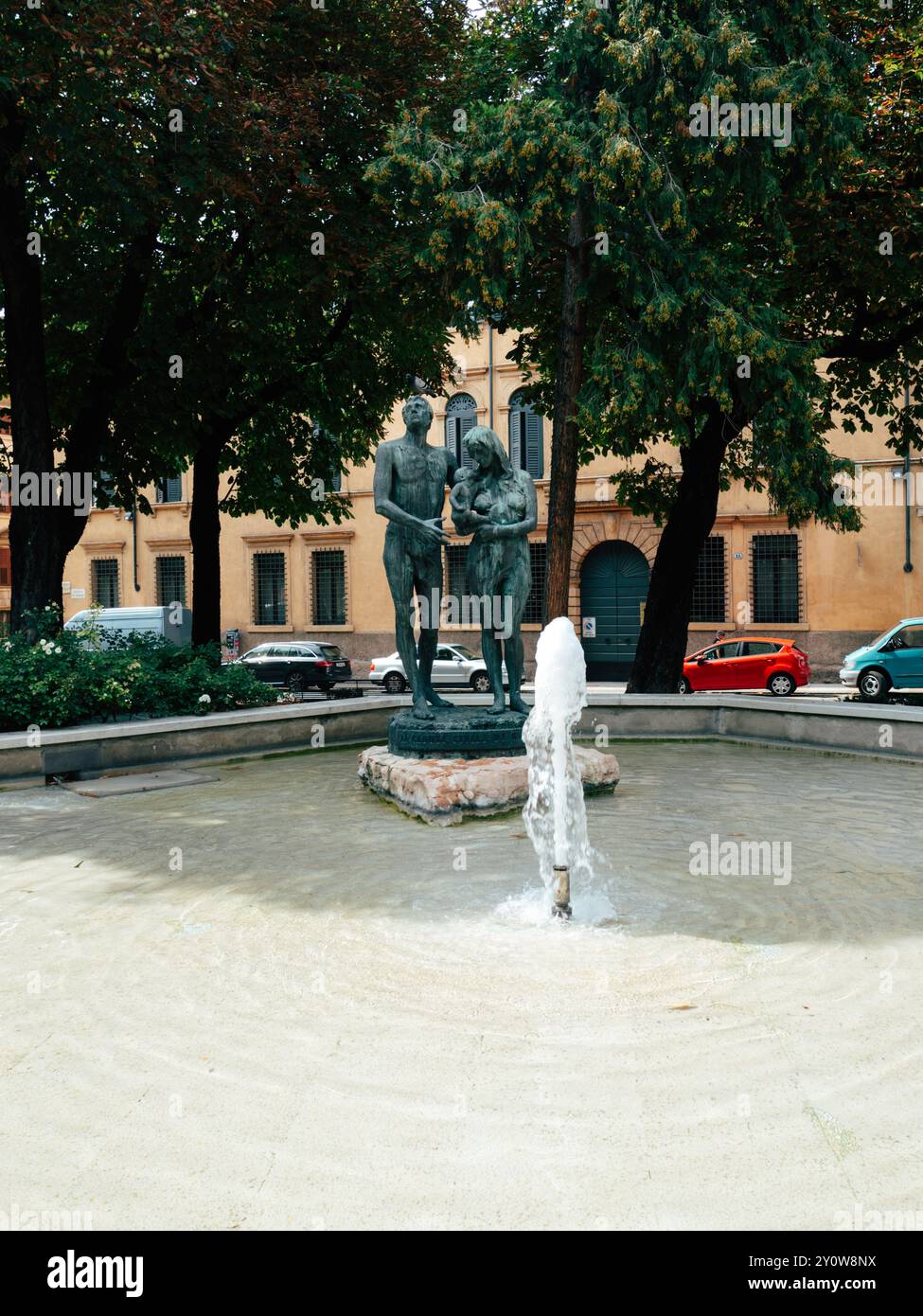 A bronze statue depicts two figures standing together beside a fountain ...