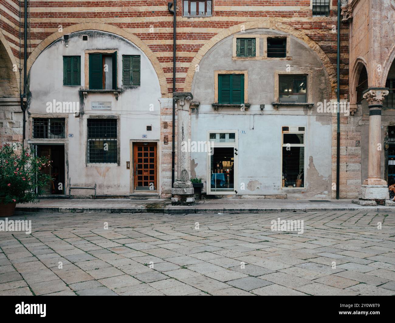In a charming Italian town square, colorful arched doorways and ...