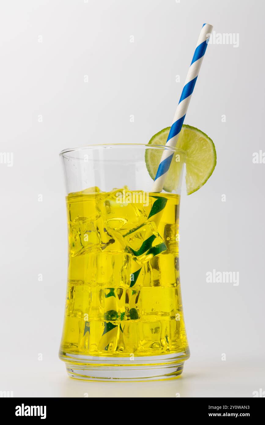ertical photo of a vibrant yellow lemonade drink with ice cubes and a ...