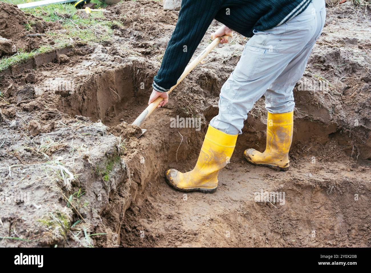 Man digging out a plant terrace of a pond Stock Photo - Alamy