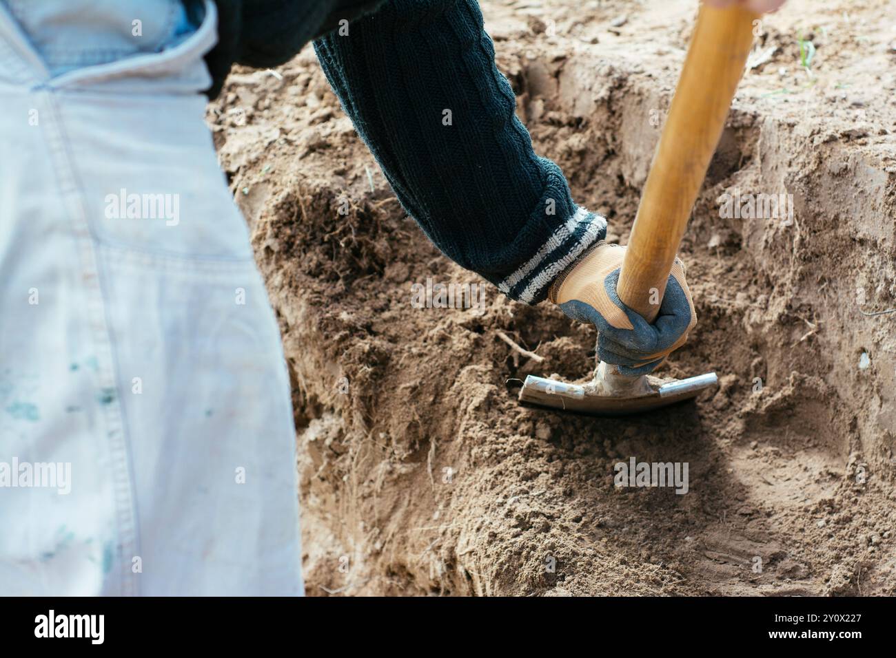 Man digging out a plant terrace of a pond Stock Photo - Alamy