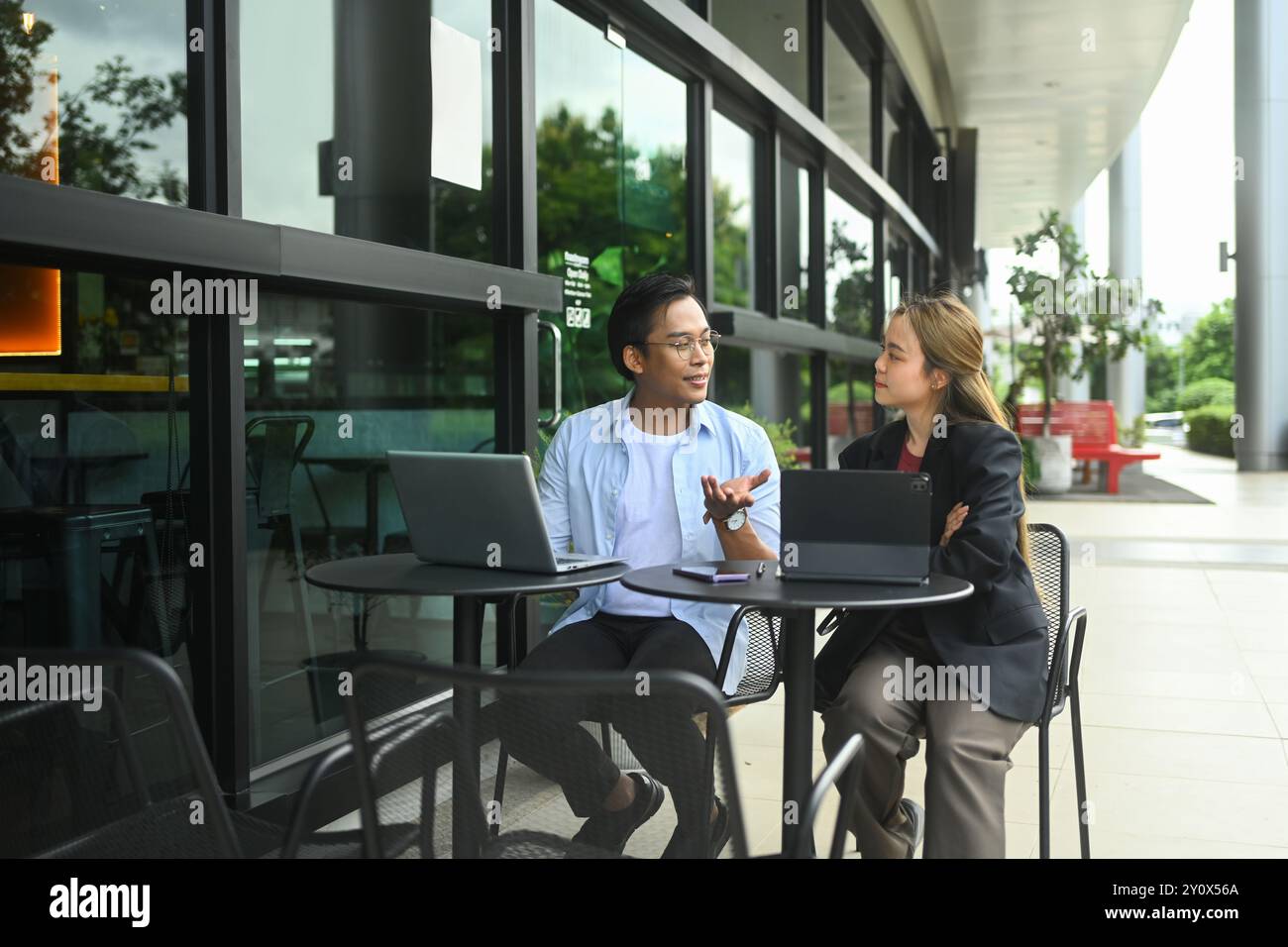 Young businesspeople having discussion at an outdoor cafe. Business ...