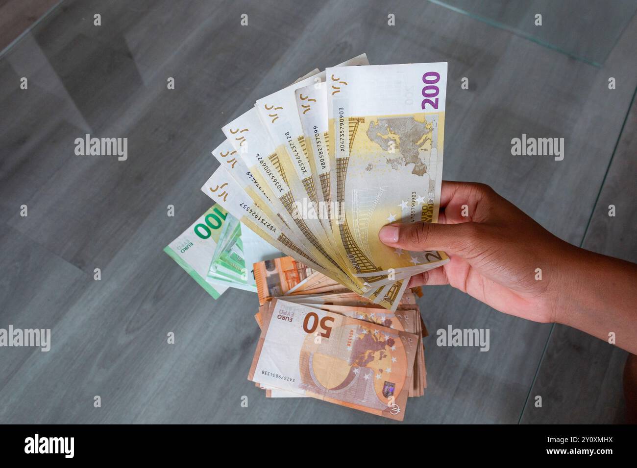 Euro bills of different amounts handed over by one hand. Concept ...