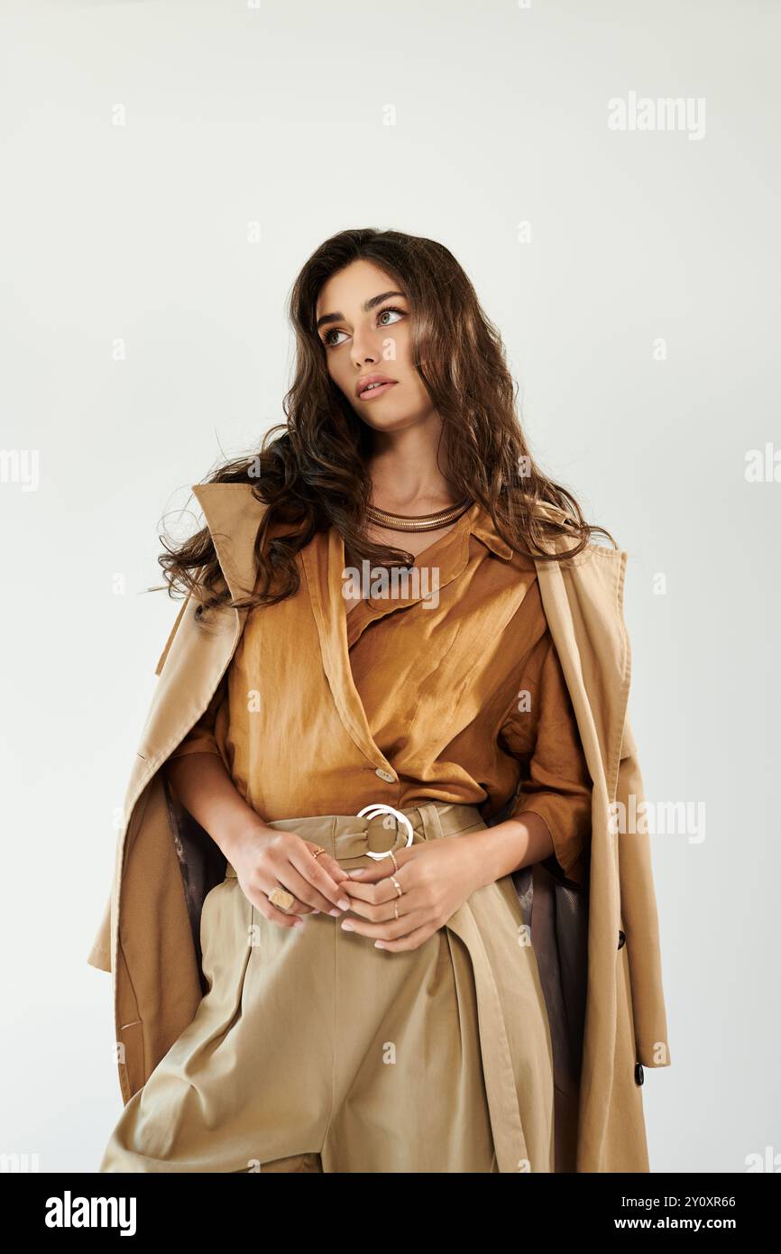 A young and beautiful woman showcases her fashionable autumn attire in ...