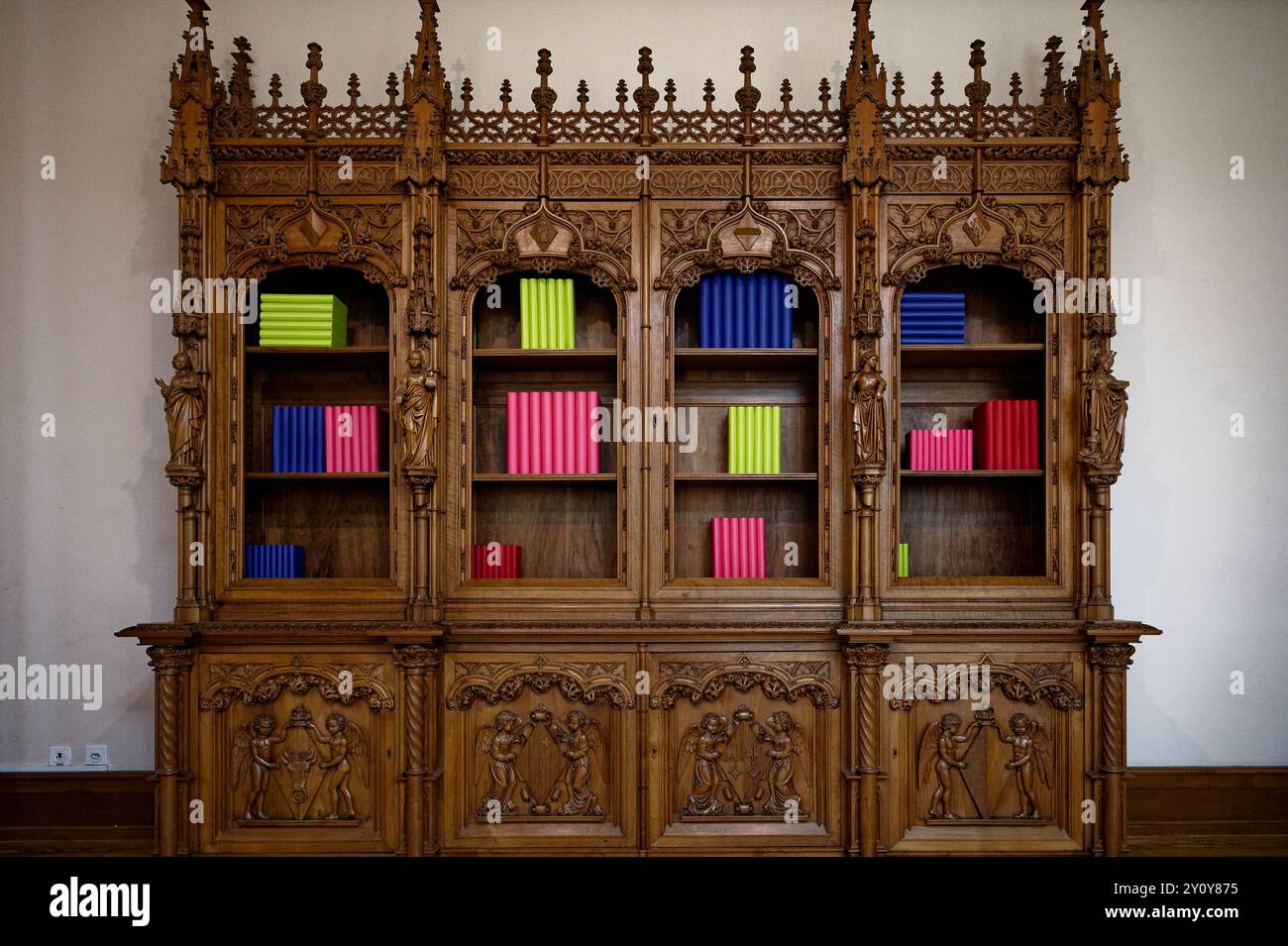 Ornate wooden bookshelf with colorful books arranged on display Stock Photo - Alamy