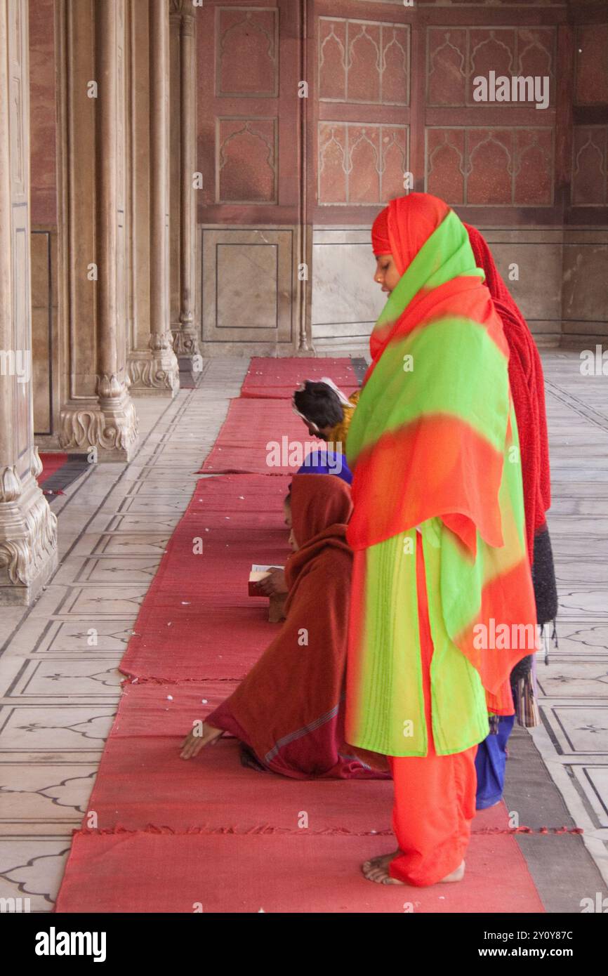 Modestly-dressed woman praying in mosque; Delhi; India; brightly ...
