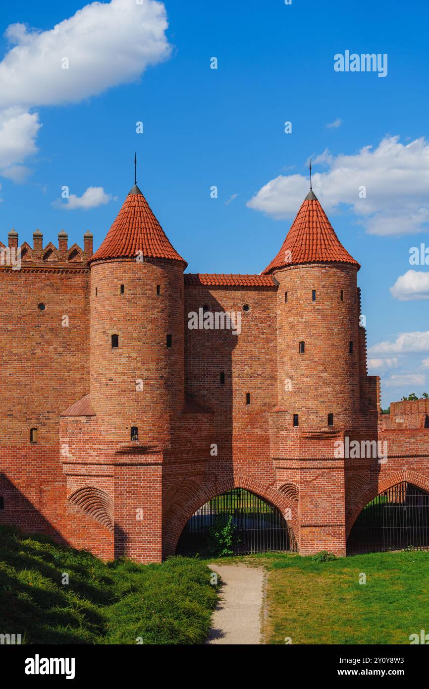 Medieval castle with two towers and a gate between them under blue sky ...
