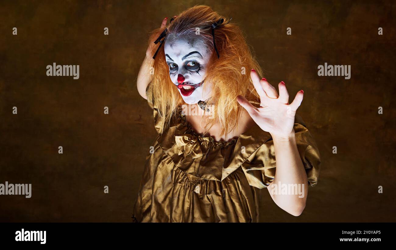 Frightening clown woman in golden gown, raising her hands with wild ...