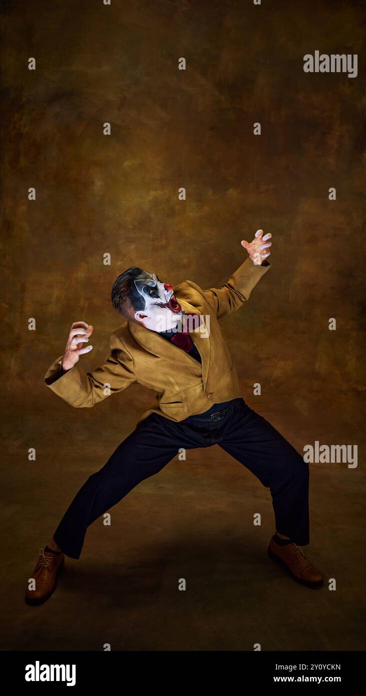 Man with horror make-up, striking wide stance, hands clawing air as he ...