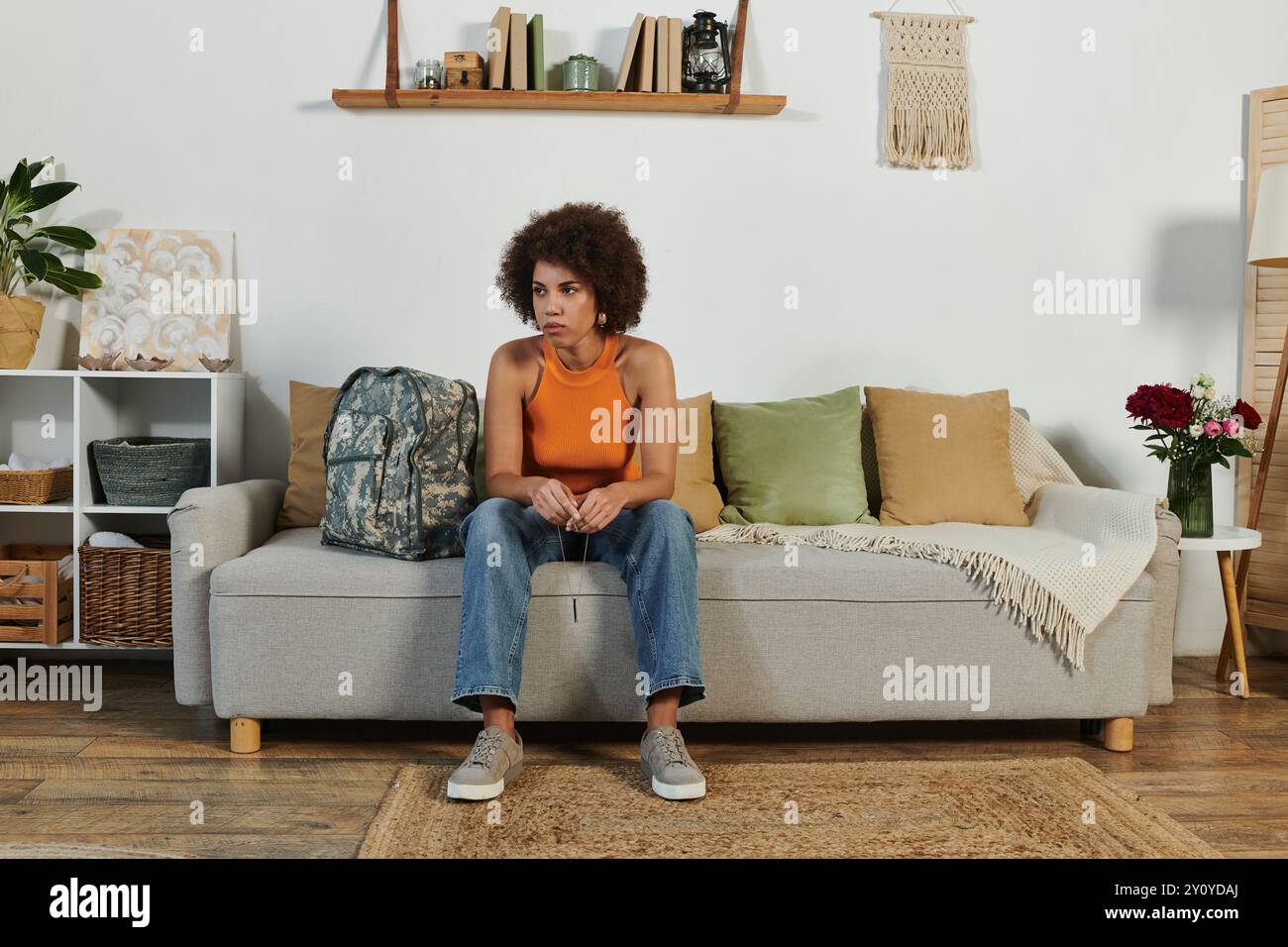 A young woman sits thoughtfully in her living room, ready to embark on ...