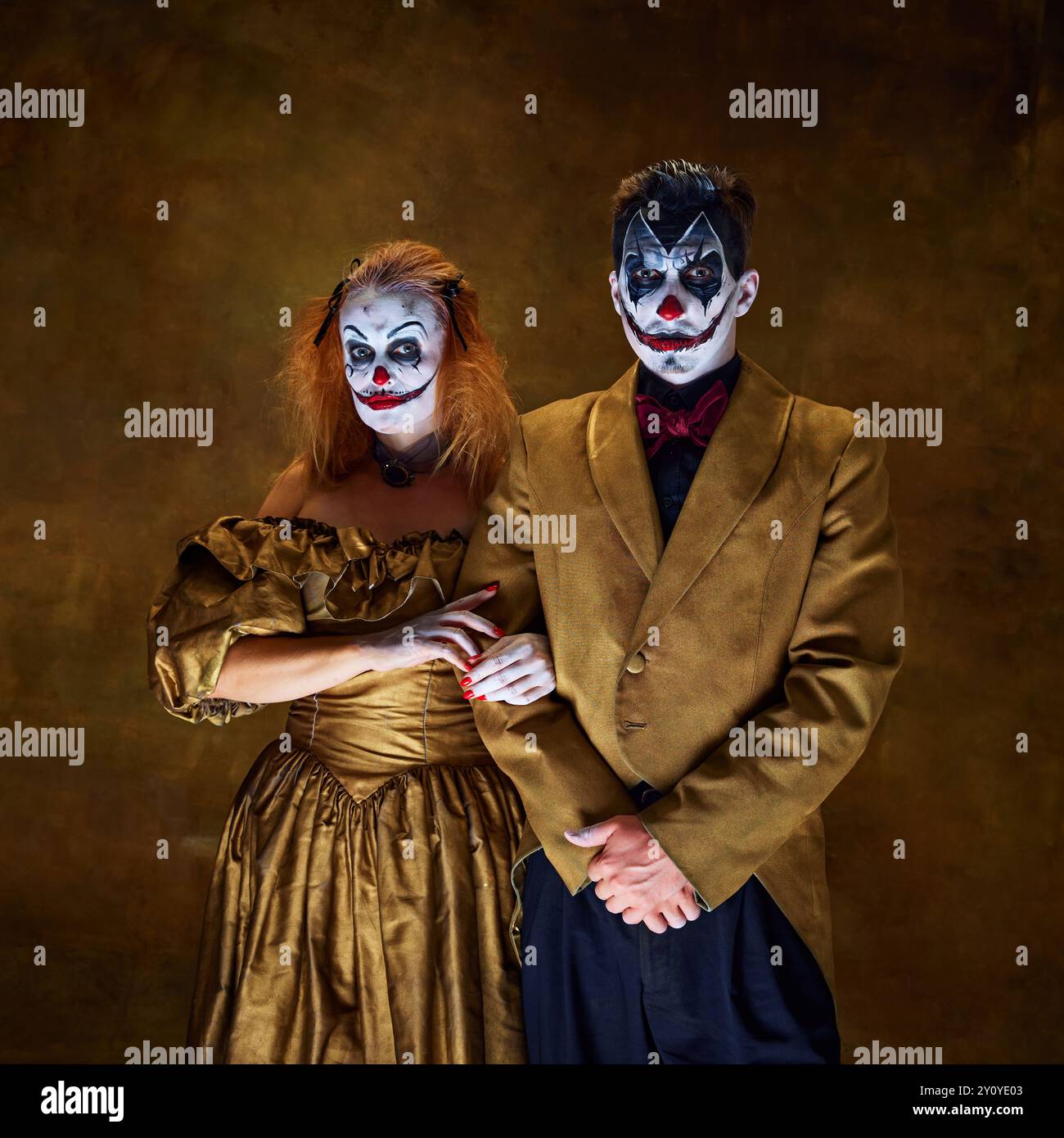 Two clowns stand together, eerily calm and formal in their stance, eyes ...