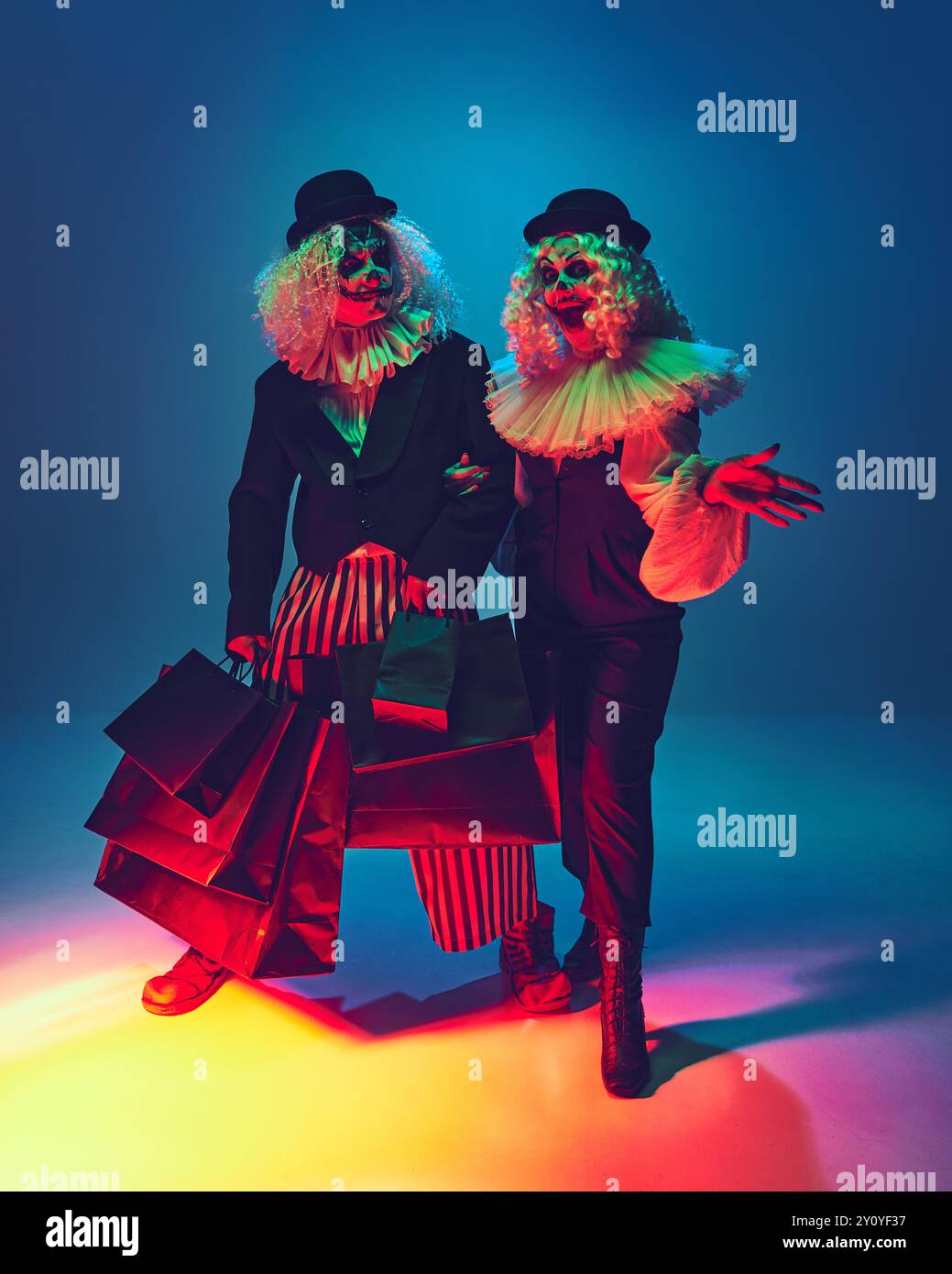 Clowns surrounded by shopping bags, neon lights casting eerie colors on ...