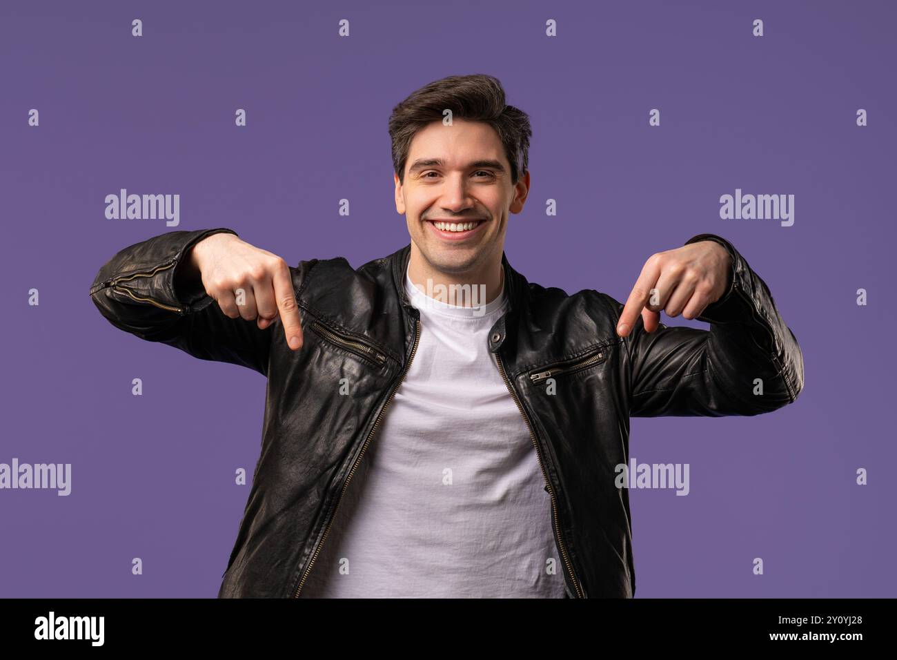 Blogger man pointing down advertising area. Violet background. Click ...
