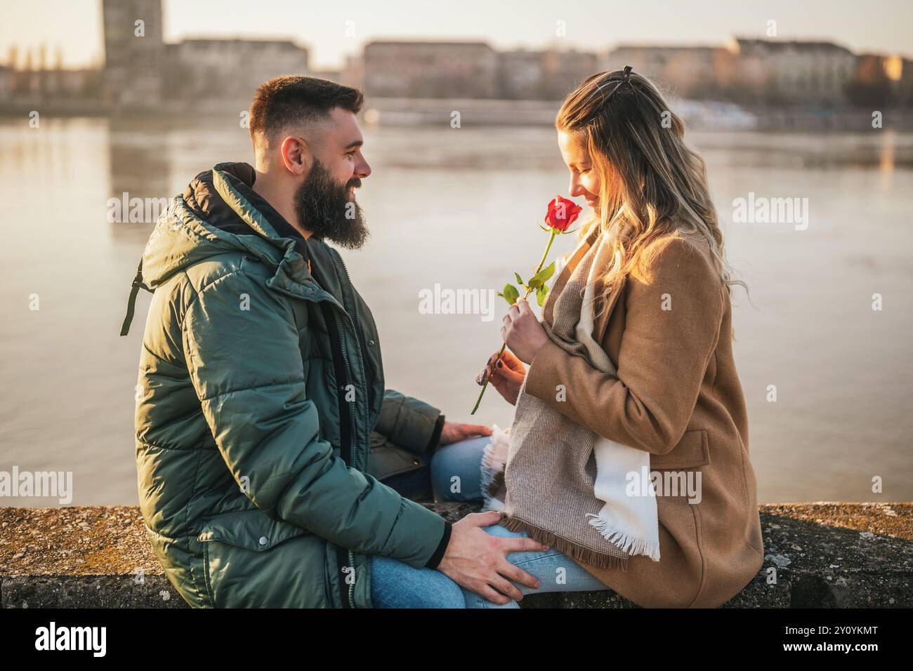 Man giving red rose to his woman while they enjoy spending time ...