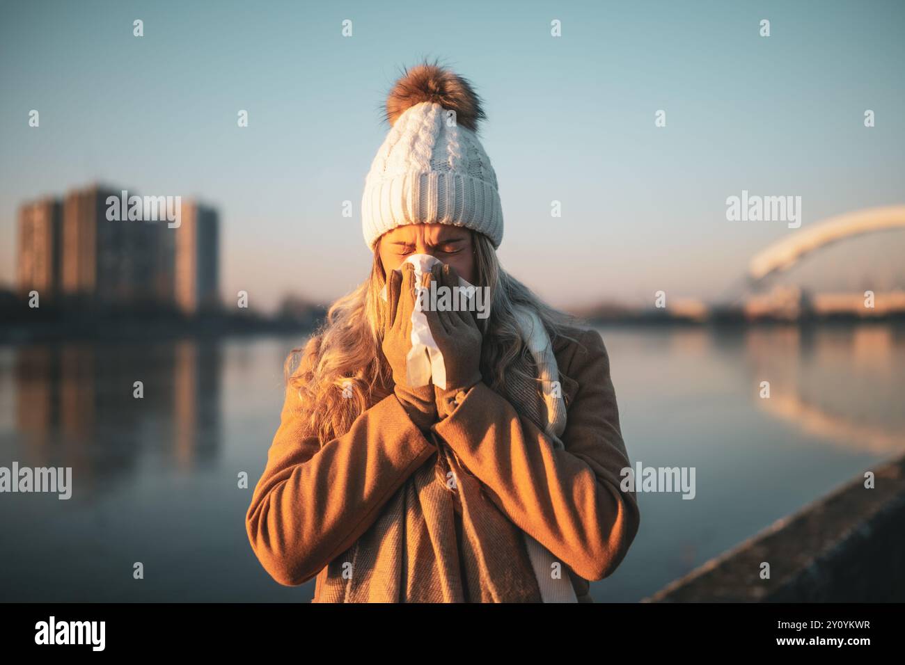 Woman in warm clothing blowing nose outdoor Stock Photo - Alamy