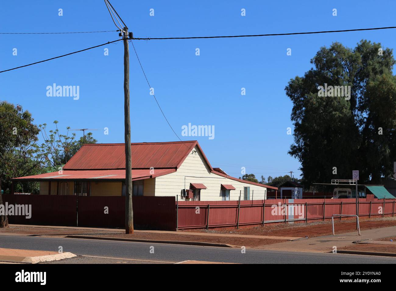 Detached residential house with corrugated sheet iron roof and fence ...