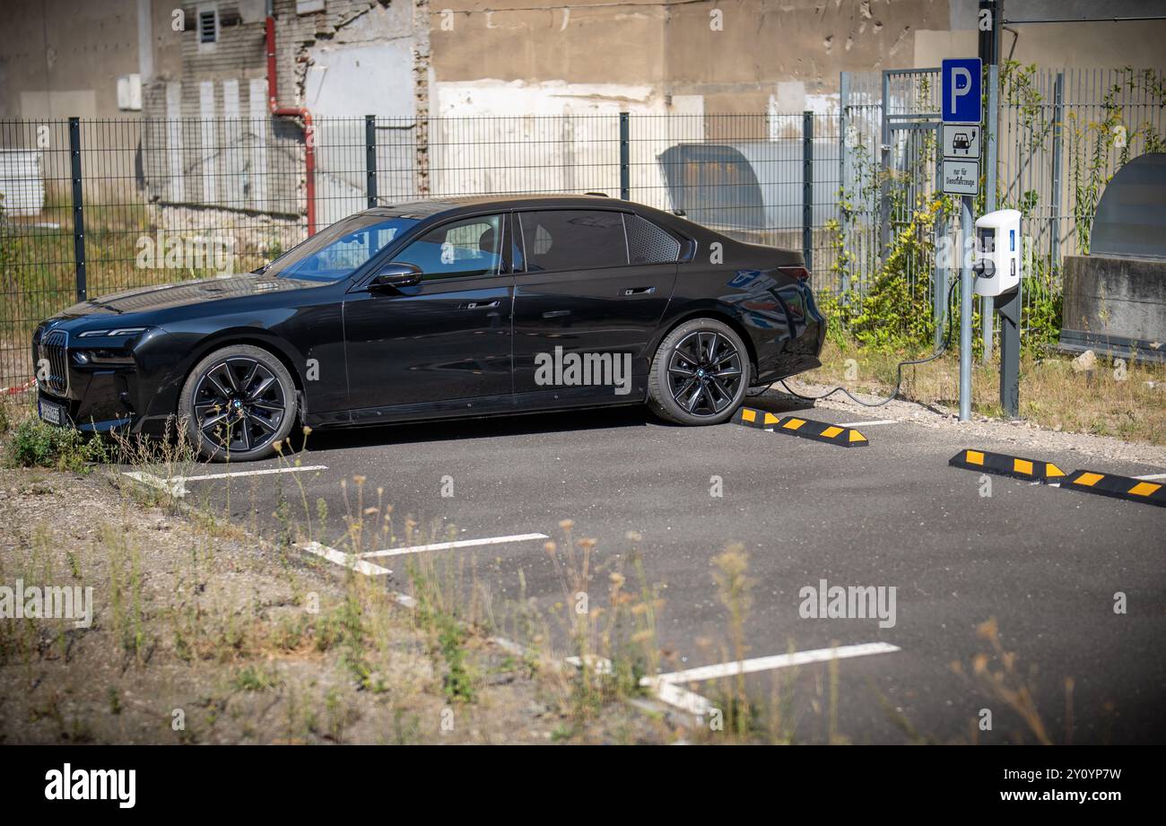 04 September 2024, Berlin: An electric vehicle parks at a wallbox in a ...