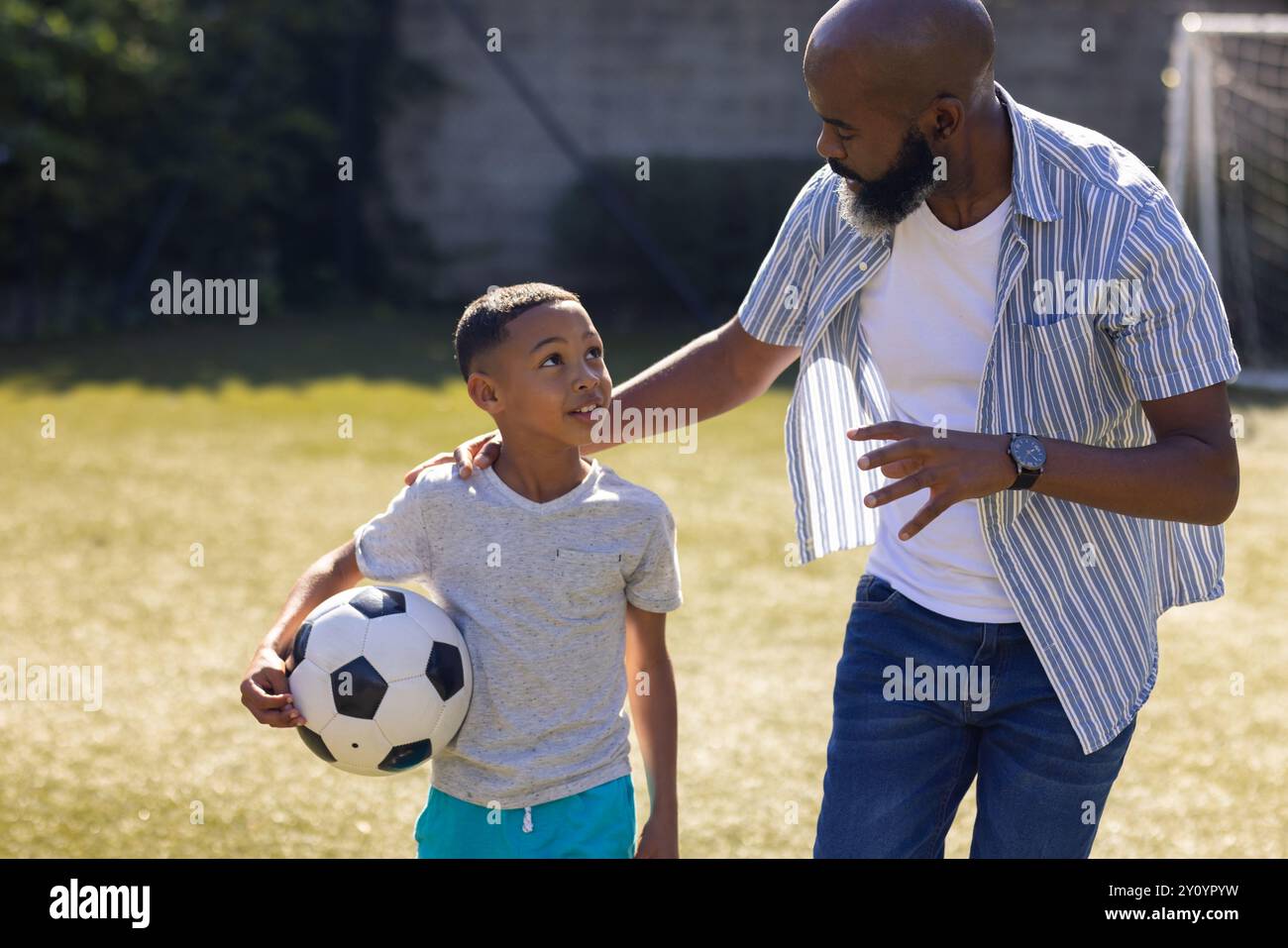 Grandfather and grandson bonding, holding soccer ball and talking on ...