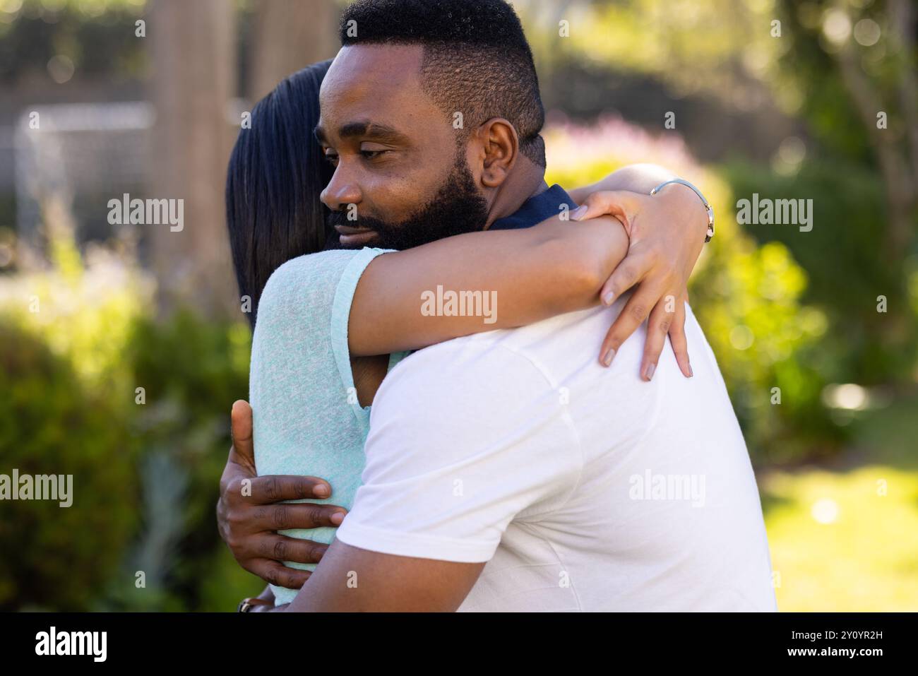 Hugging each other, man and woman sharing comforting moment outdoors ...
