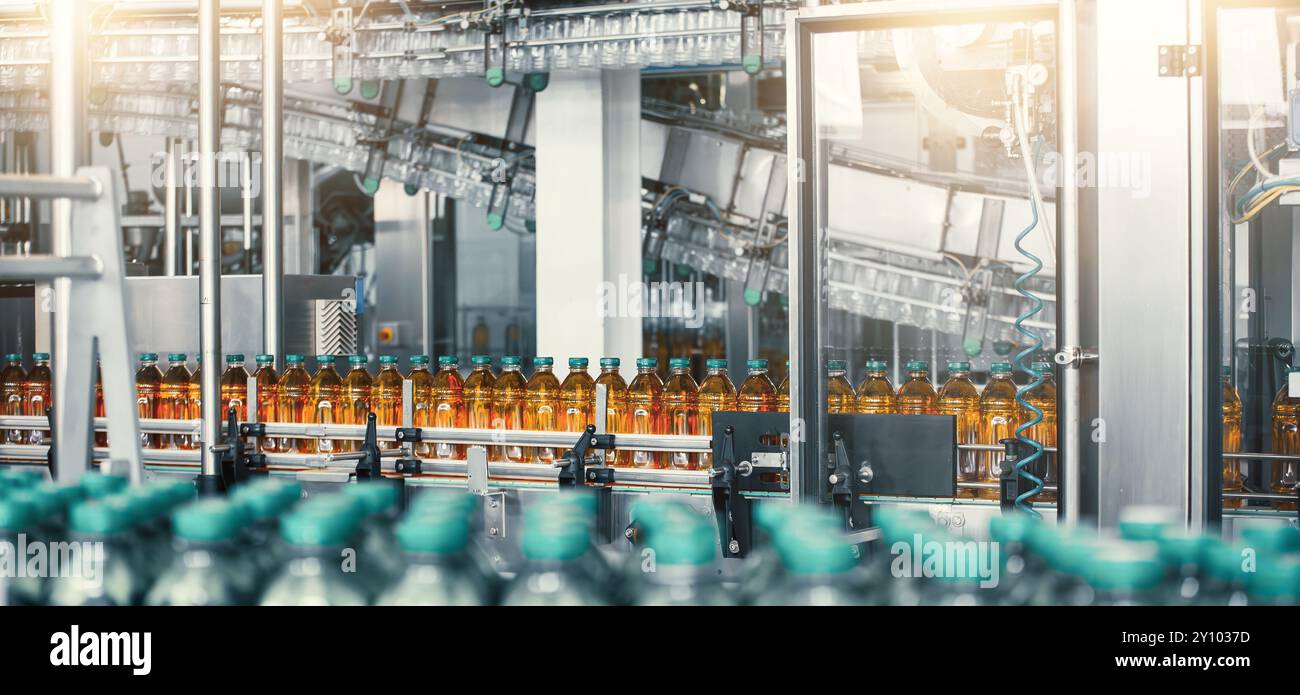 Bottling plant with conveyor line filled with plastic bottles for liquid packaging, industrial ...