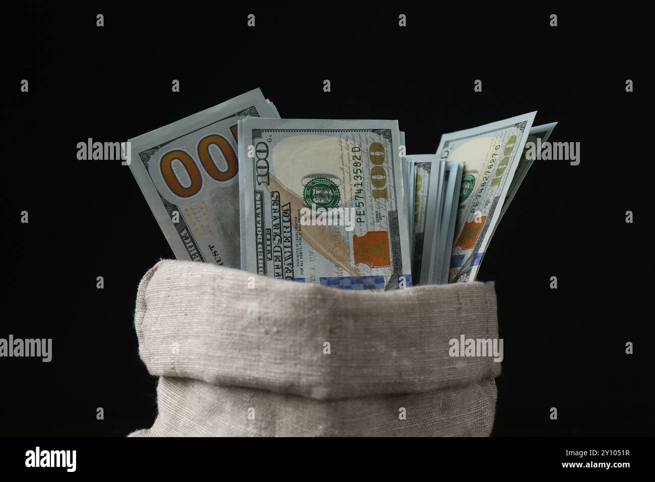Dollar banknotes in sack against black background Stock Photo - Alamy